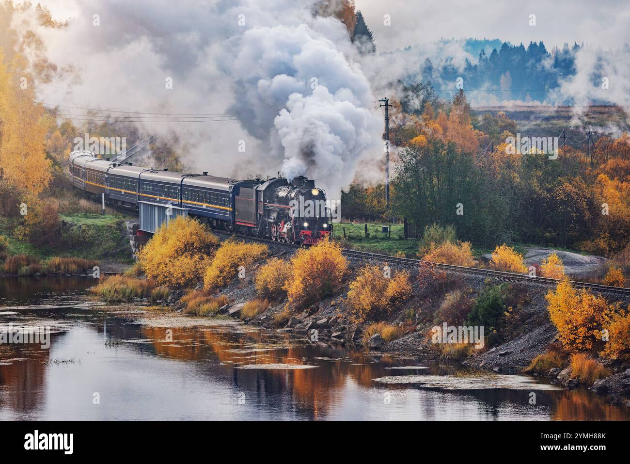 Retro steam train moves along the lake at autumn morning Stock Photo ...