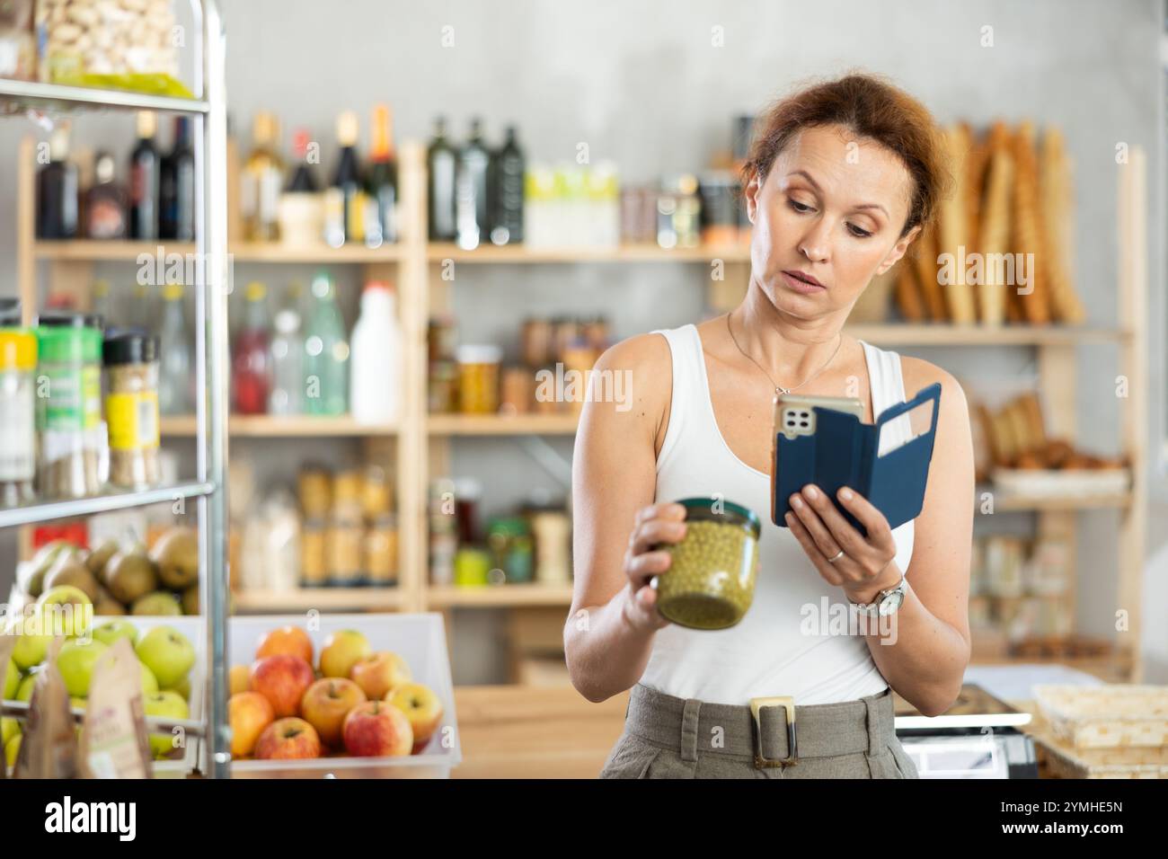 Adult woman scanning qr code of green peas Stock Photo - Alamy