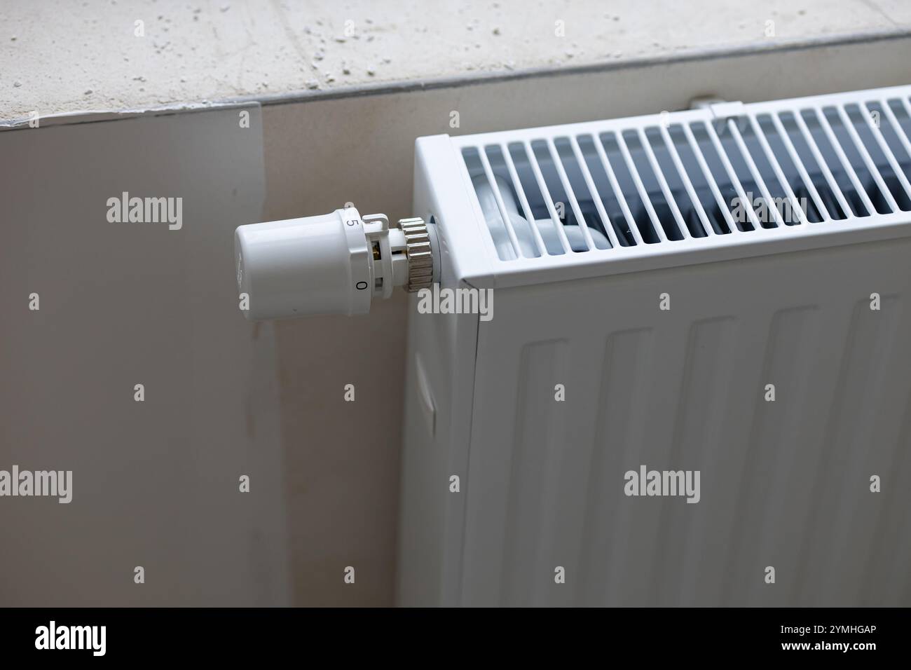 Modern white radiator with adjustable thermostatic valve installed near ...