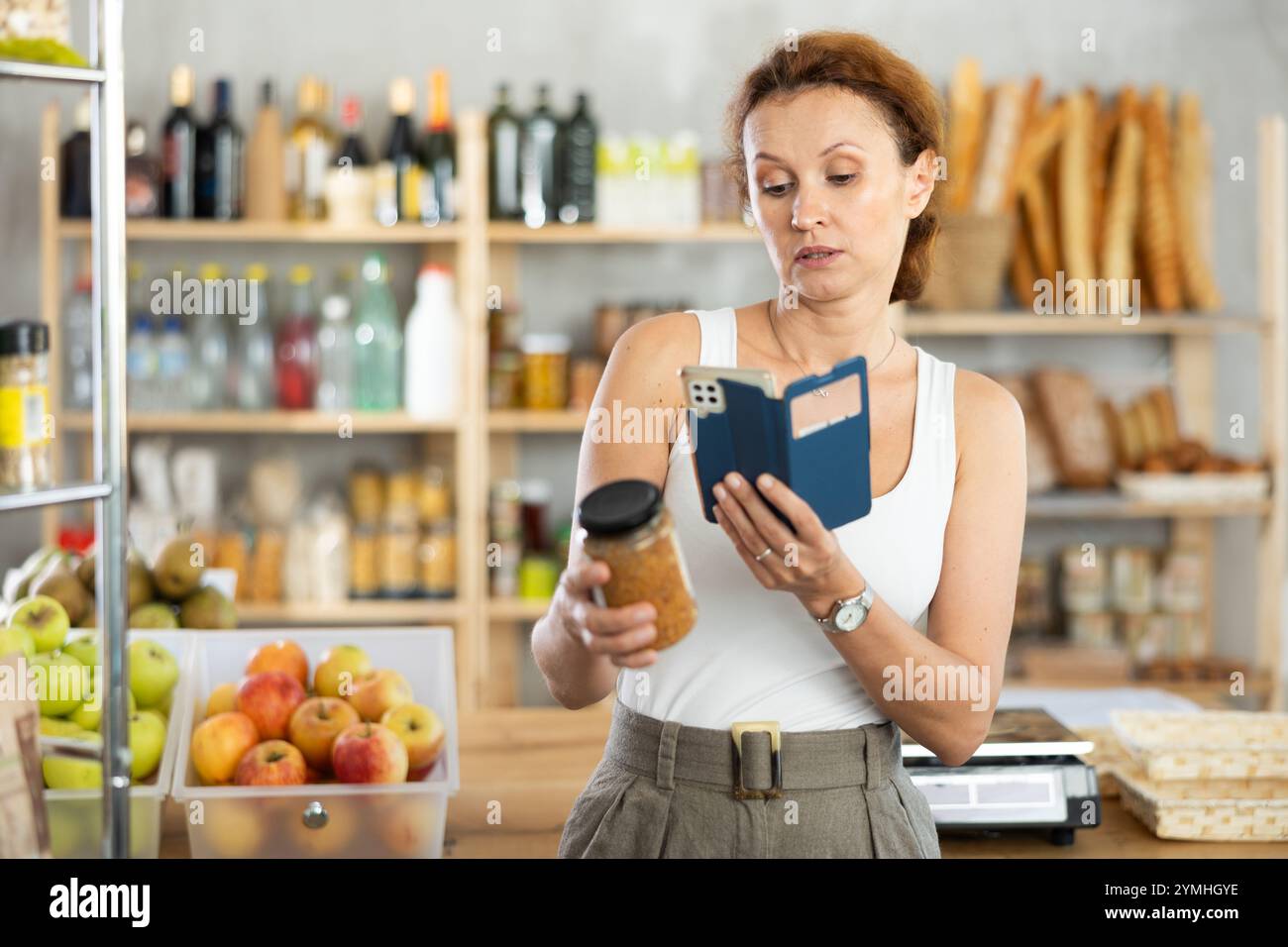 Adult woman scanning qr code of lentils Stock Photo - Alamy