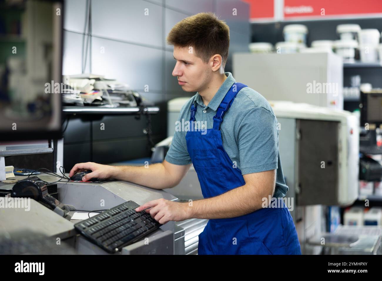 Man in uniform operating computerised machne to mix paint Stock Photo ...