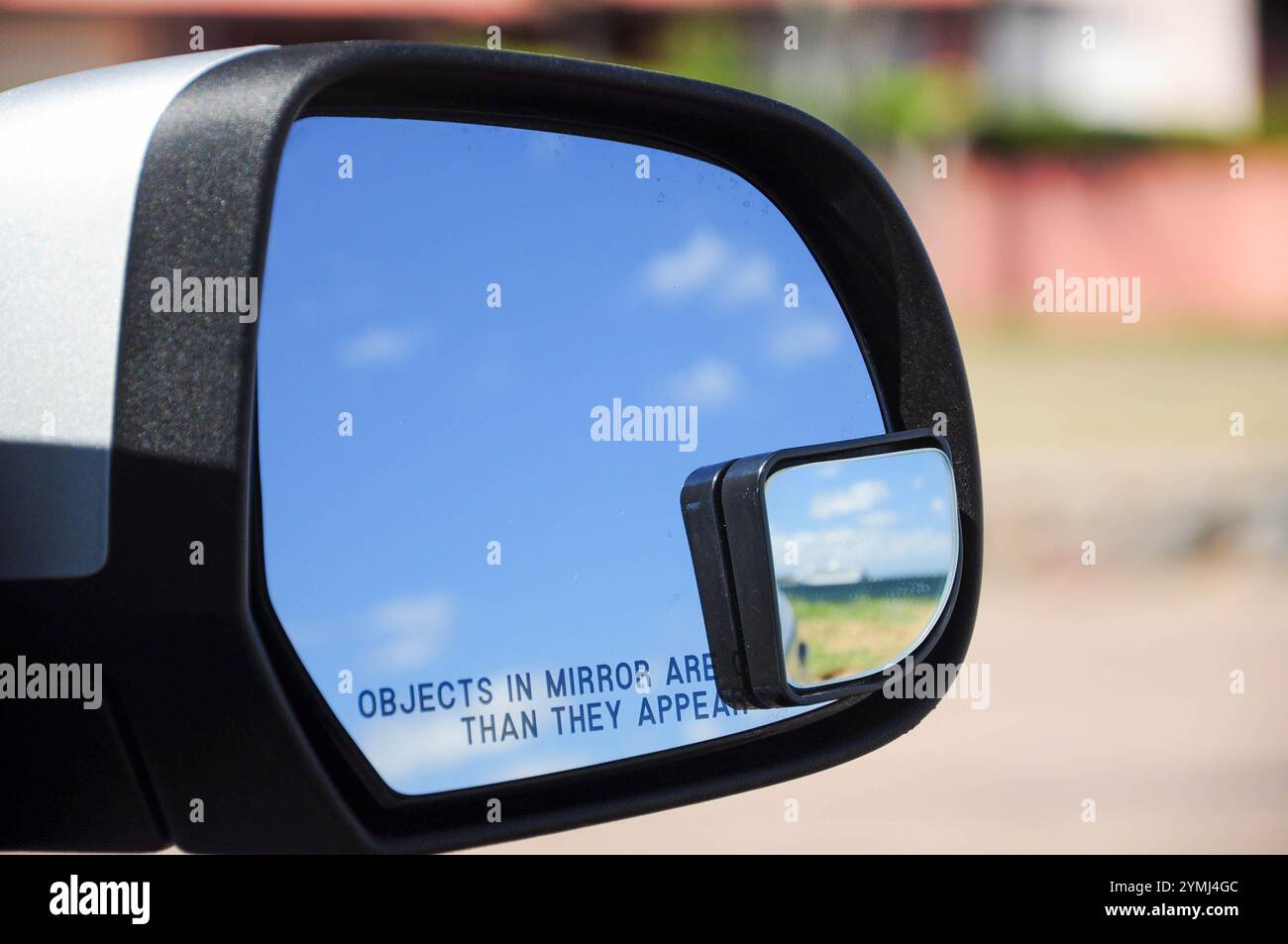 Rearview mirror with blue sky and clouds, highlighting depth and ...