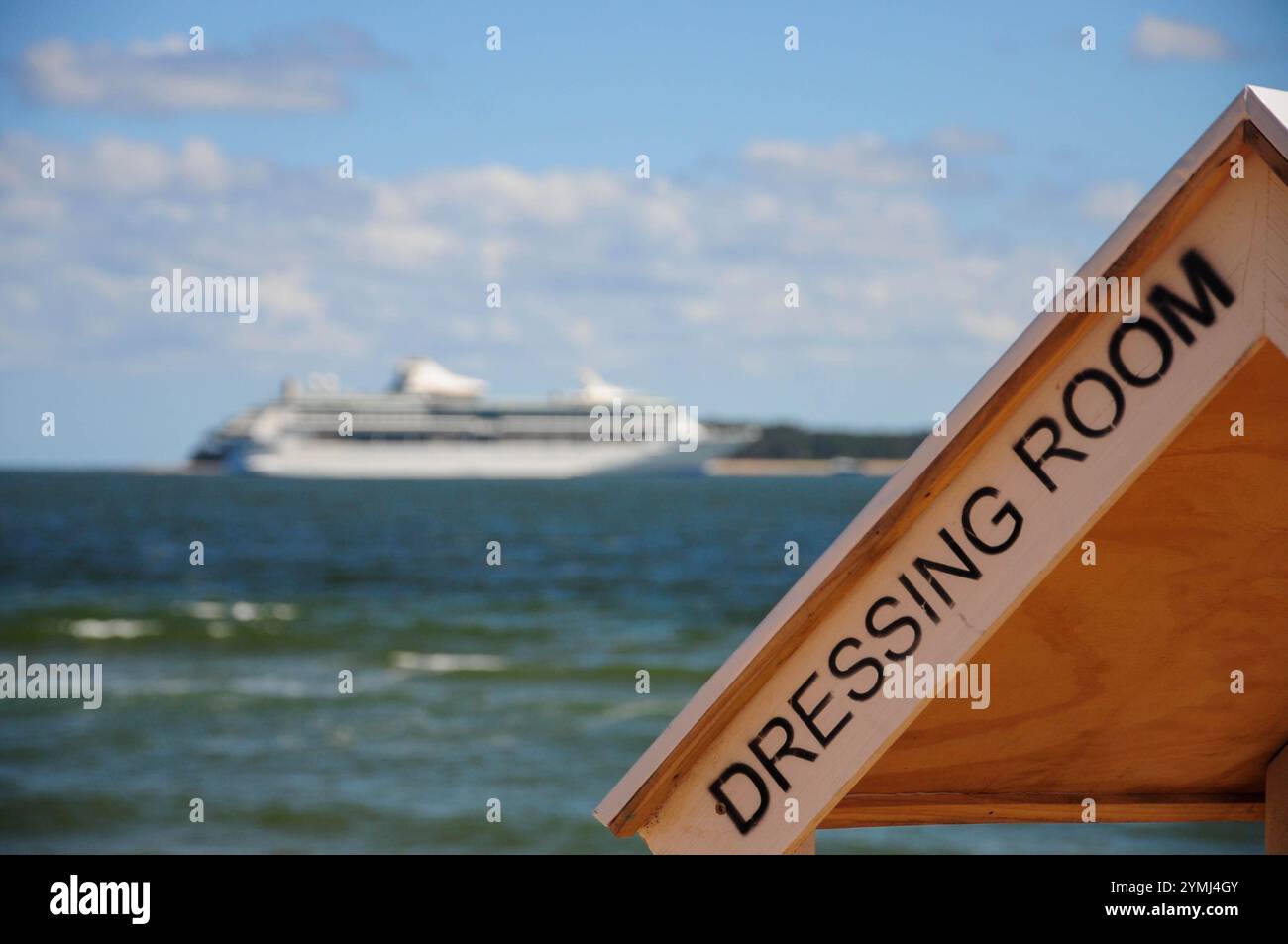 Coastal view: cruise ship horizon and wooden dressing room sign in ...
