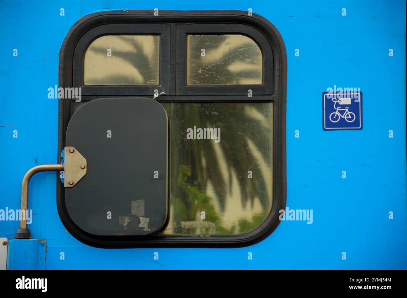 Palm tree reflections in train window with bike sign against blue ...