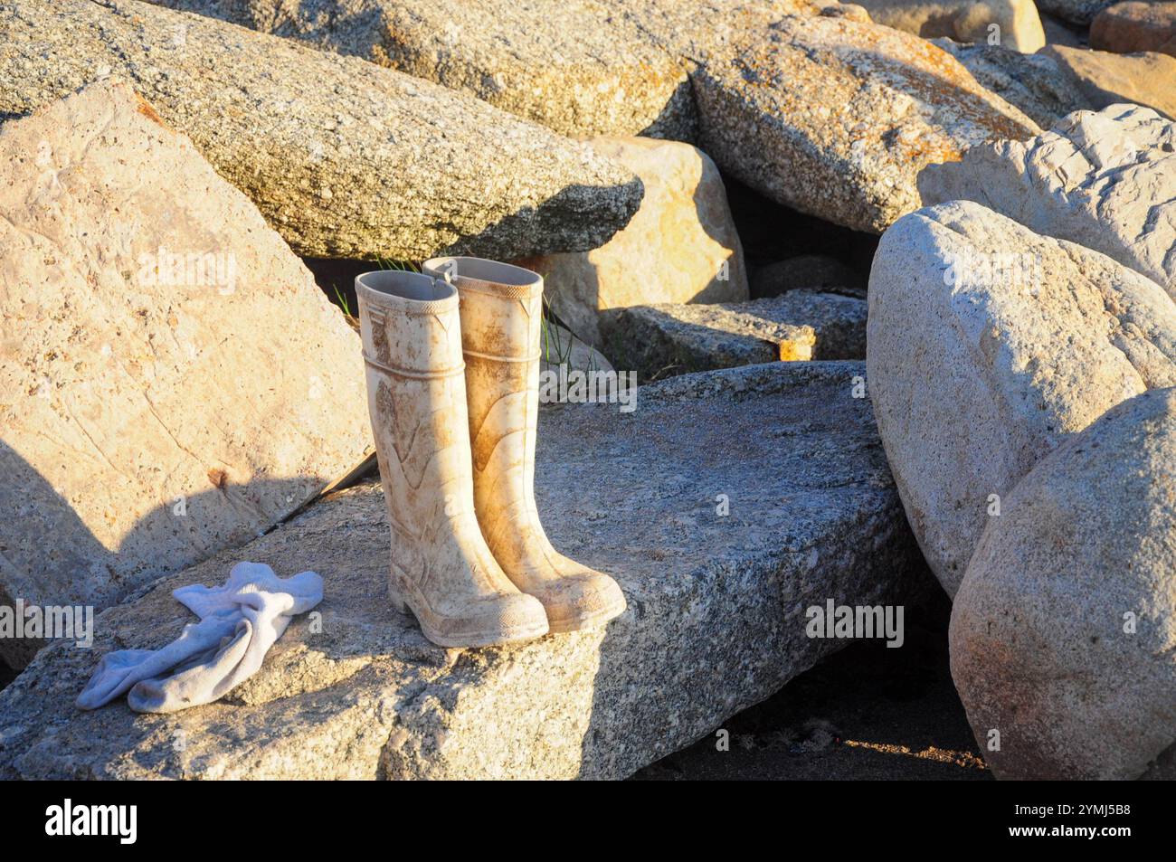 Worn-out boots and socks on boulders in warm afternoon sunlight Stock ...