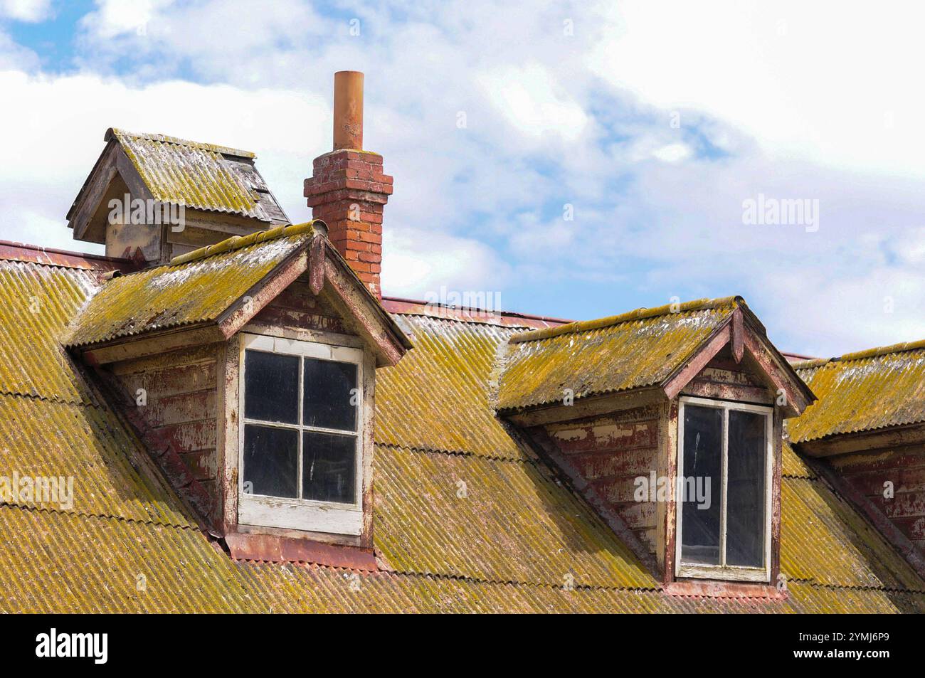 Weathered rooftop with rustic dormer windows, aged architecture under ...