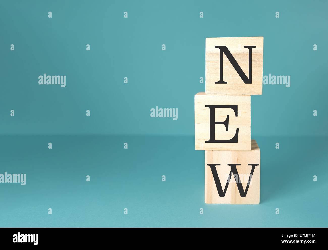 Three wooden blocks stacked on top of each other with the letters NEW ...