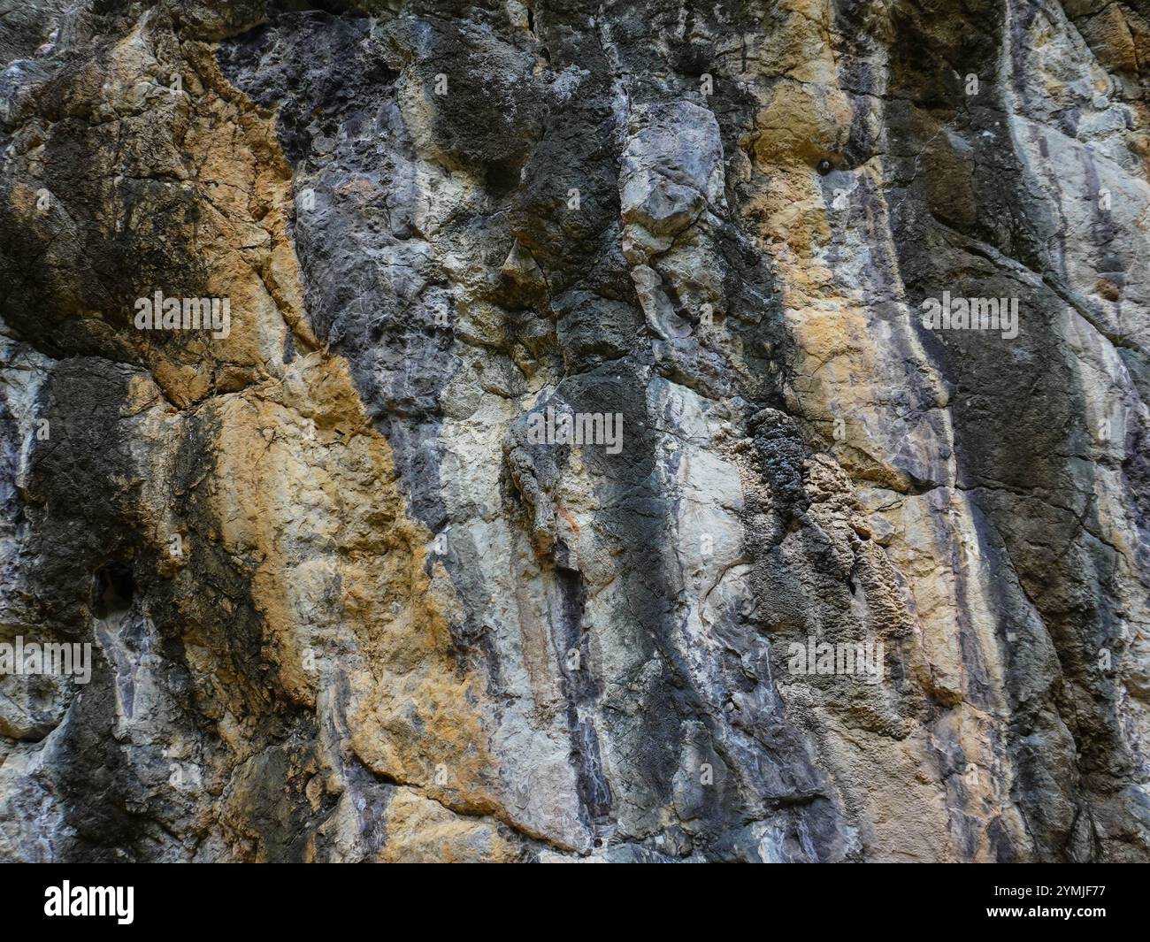 Amazing hillside cliff with compressed layer rock structure of volcanic ...