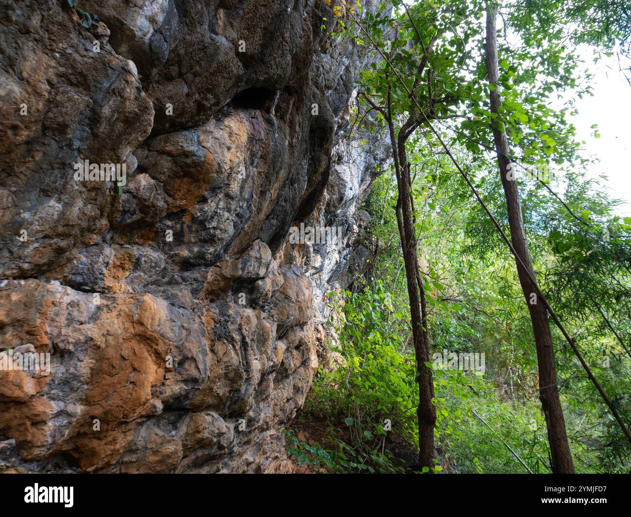 Amazing hillside cliff with compressed layer rock structure of volcanic ...
