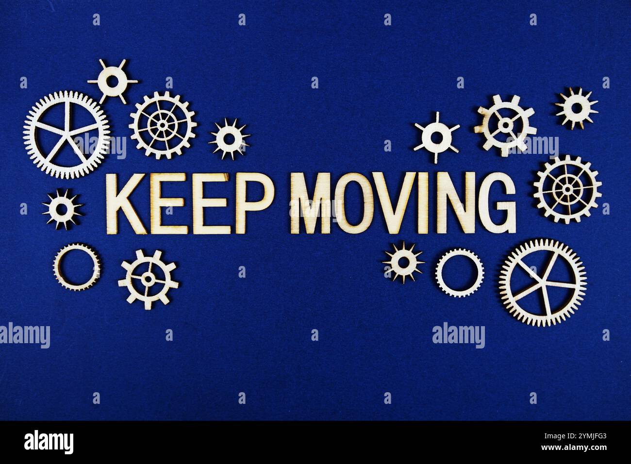 Keep Moving alphabet letters with gears element on navy blue background ...