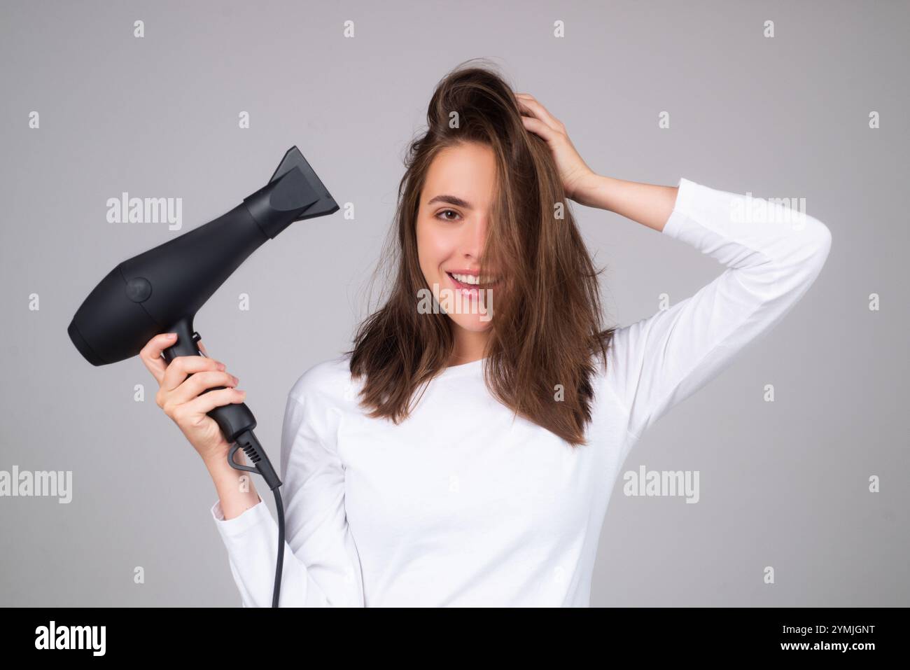 Woman with hairdryer isolated on studio background. Girl hold hairdryer ...