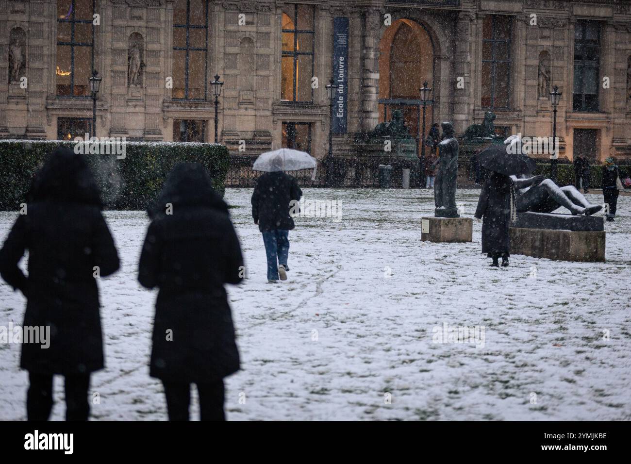 People walk by the Louvre School during the snowfall of Storm Caetano ...