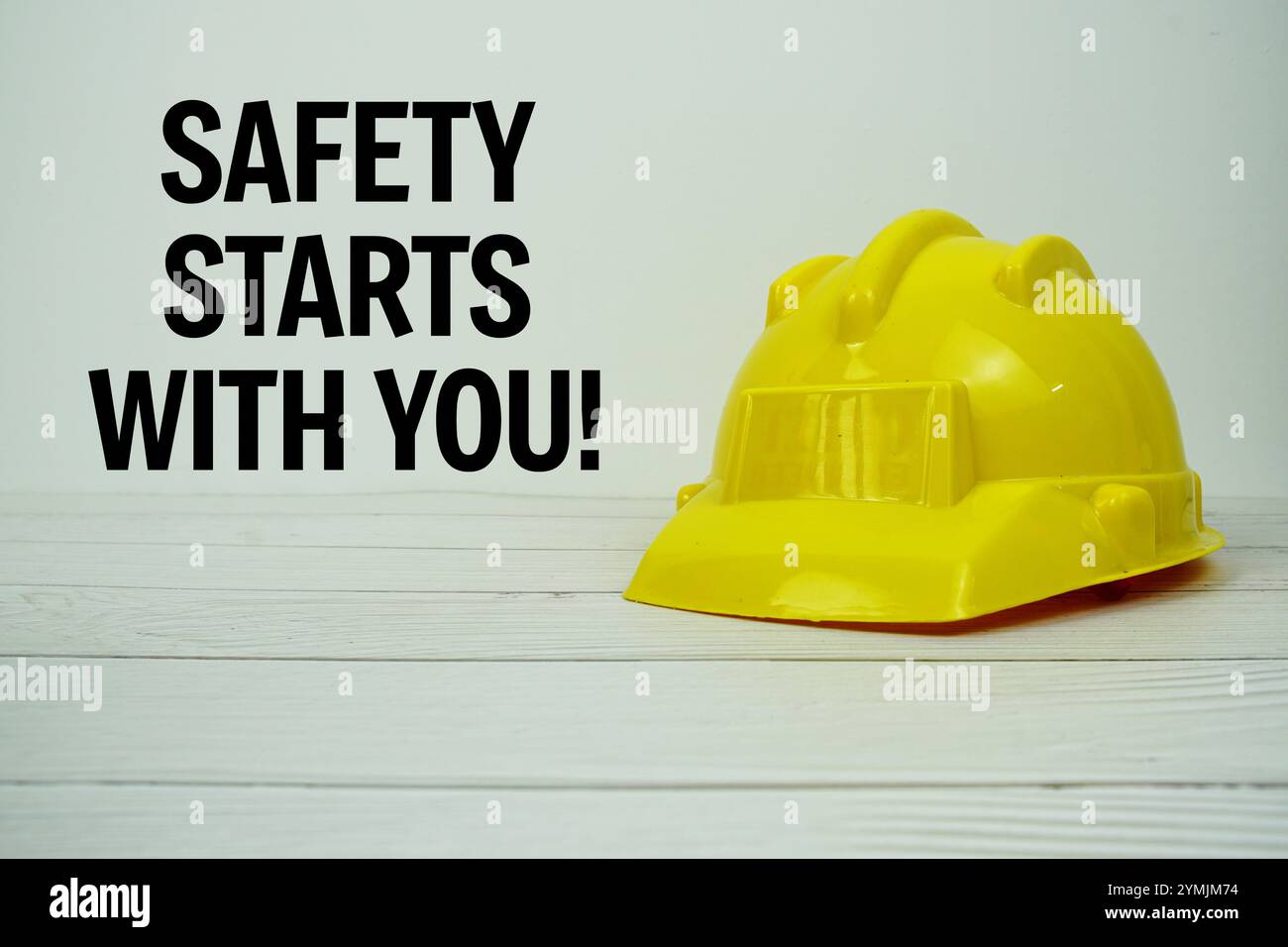 Safety Starts With You! text on blackboard with safety helmet on wooden ...
