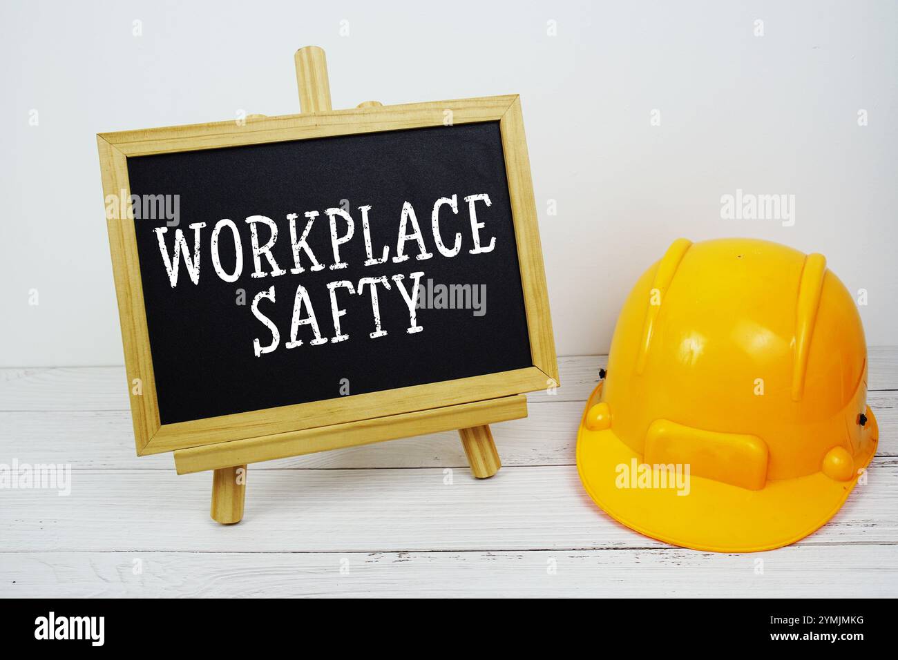 Workplace Safety text on blackboard with safety helmet on wooden ...