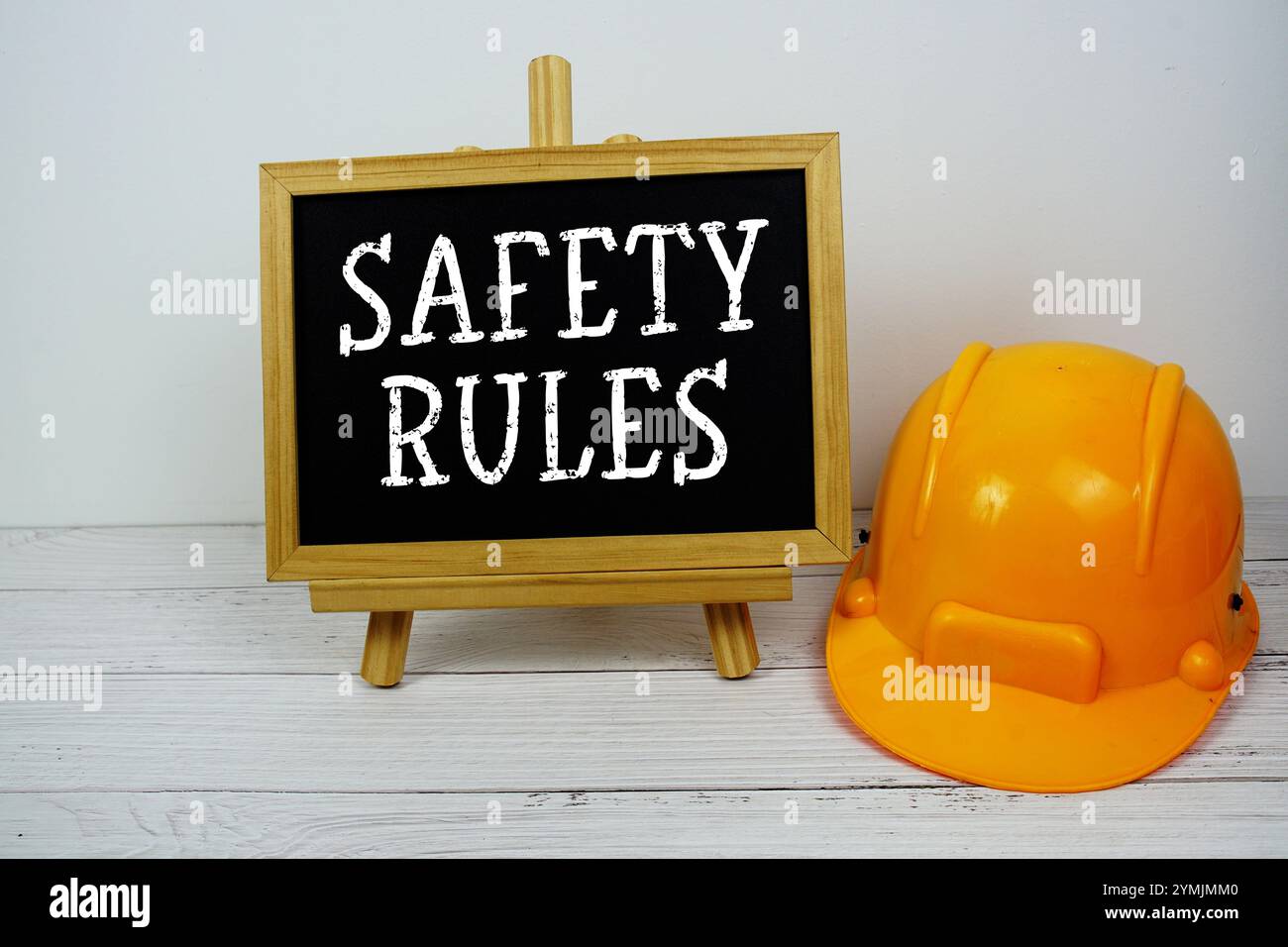 Safety Rules text on blackboard with safety helmet on wooden background ...