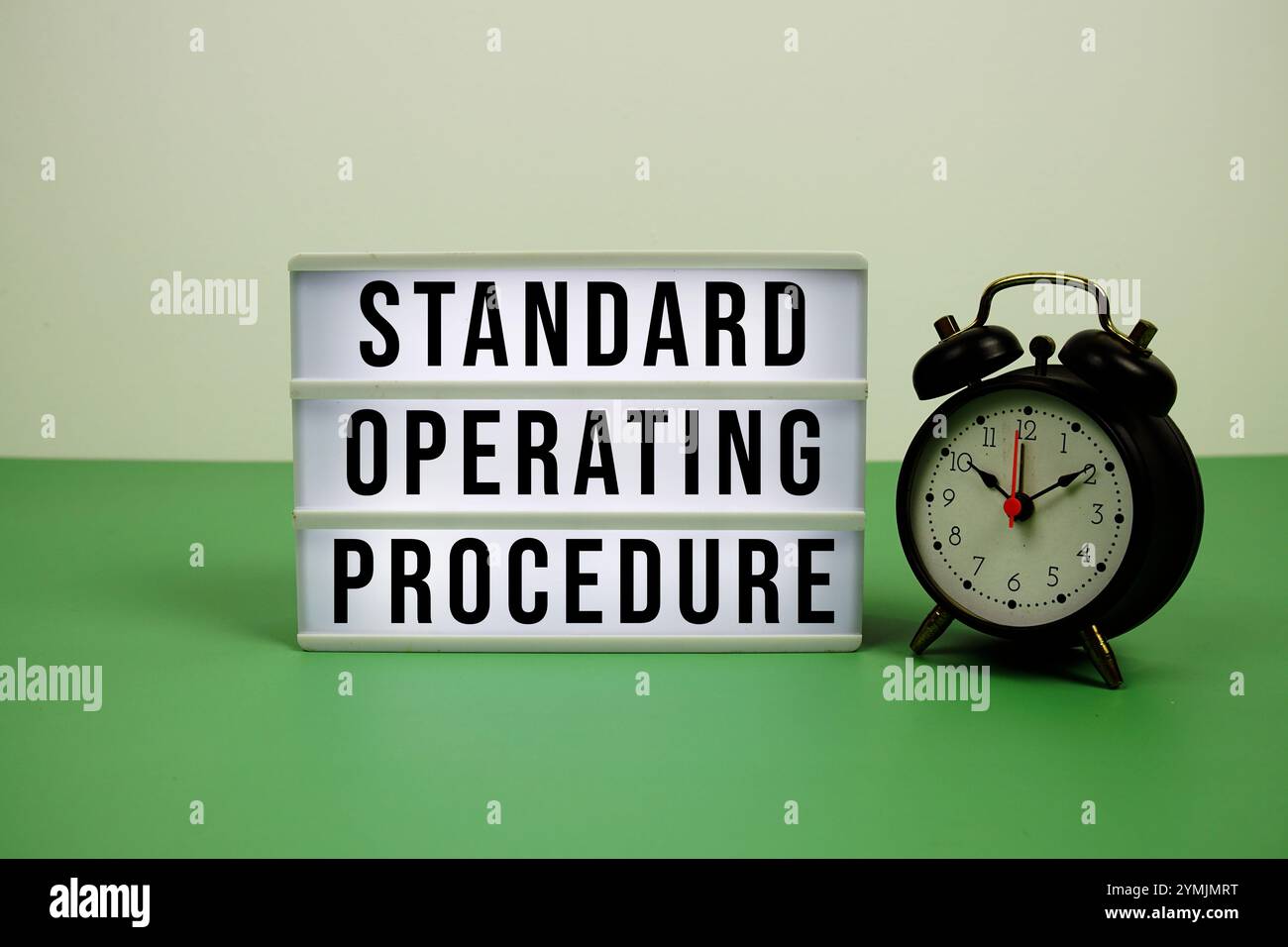 Standard Operating Procedure text on LED lightbox with alarm clock on green background Stock ...