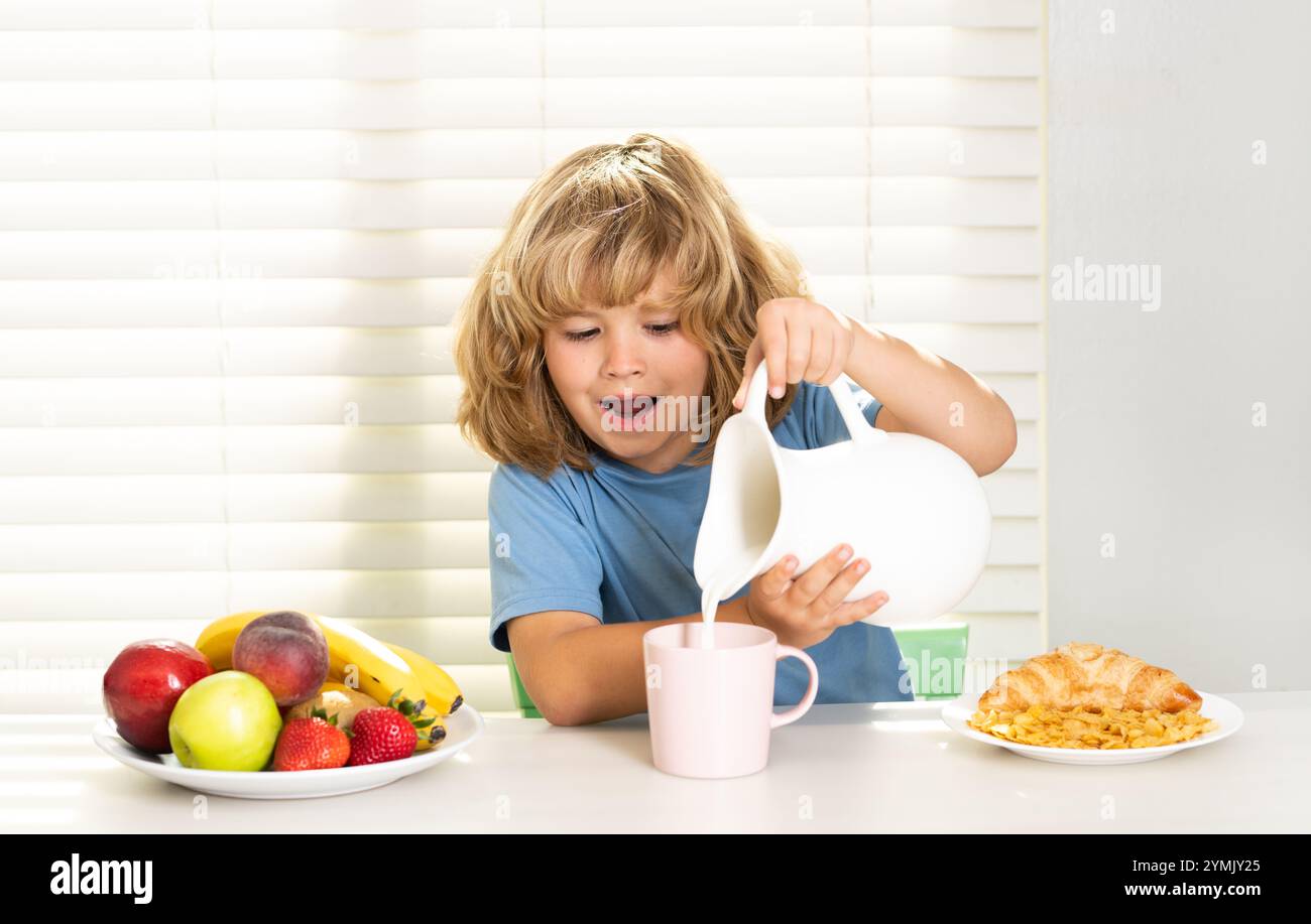 Kid pouring whole cows milk. Kid preteen boy in the kitchen at the ...