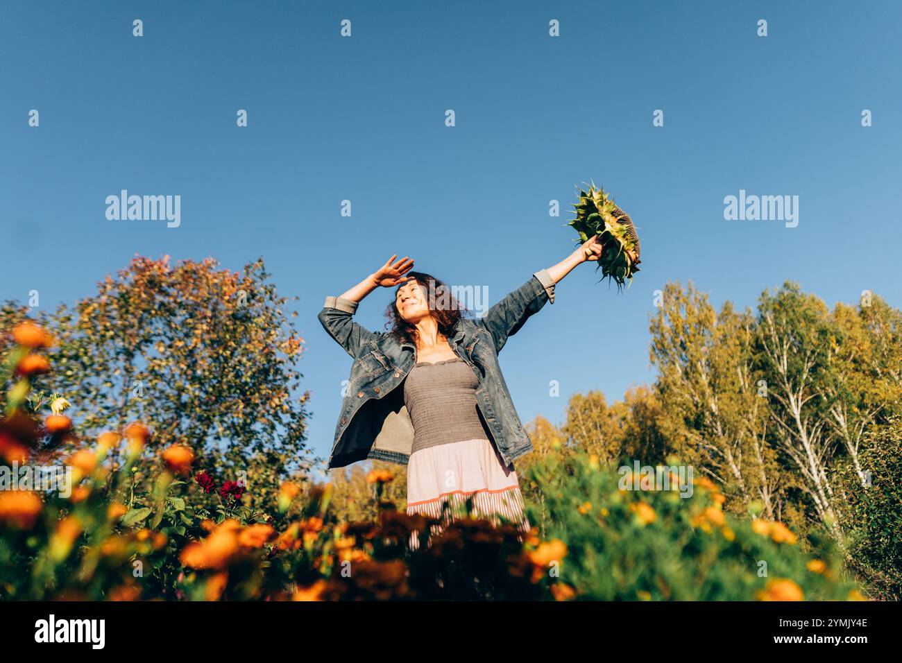 Cheerful woman with sunflower, representing the beauty of eco-friendly ...