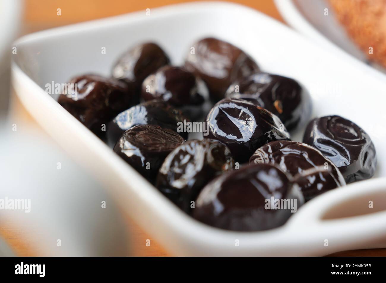 A plate filled with Delicious Black Olives is presented beautifully in ...