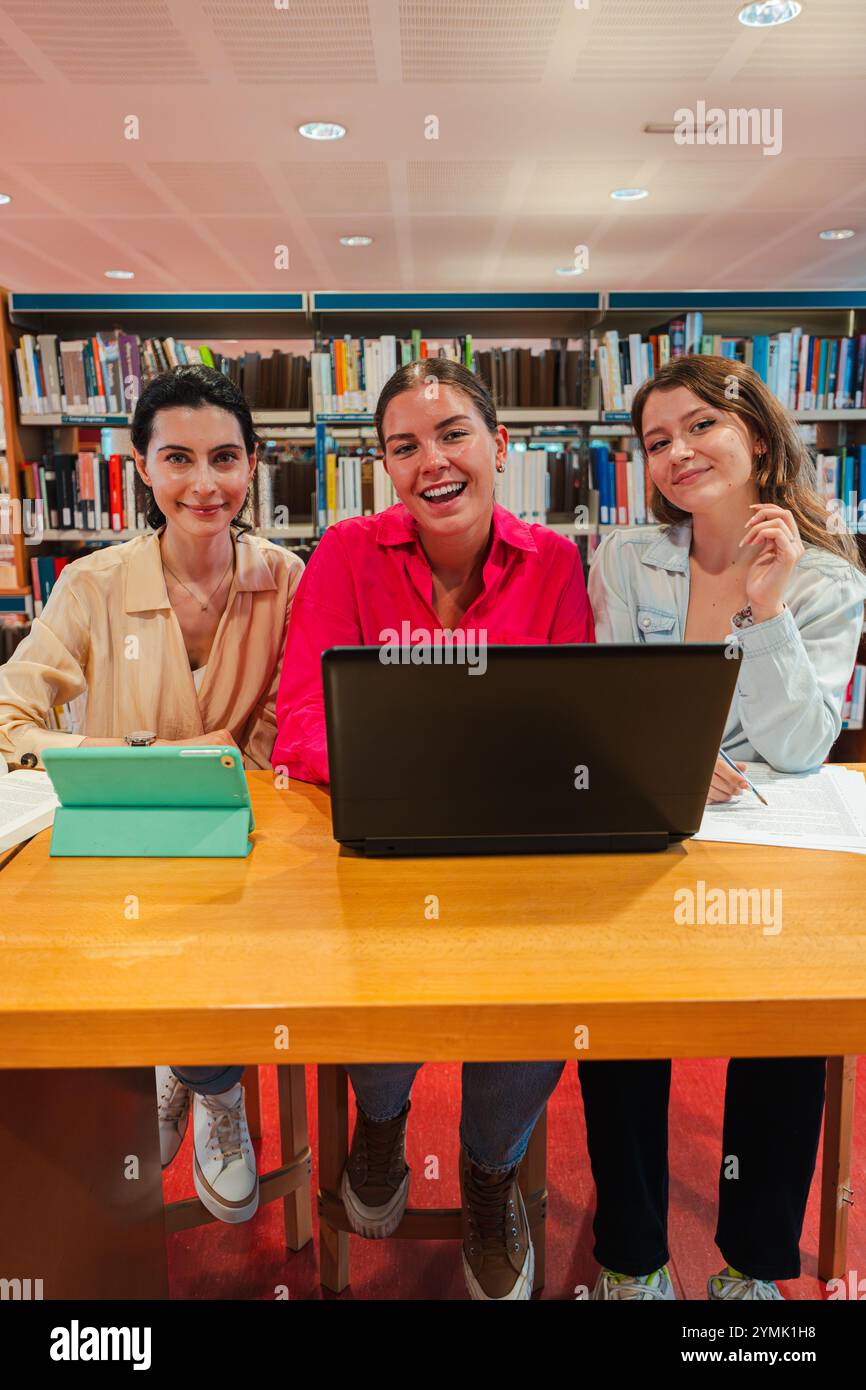 three smiling students with laptop and notebooks Stock Photo - Alamy