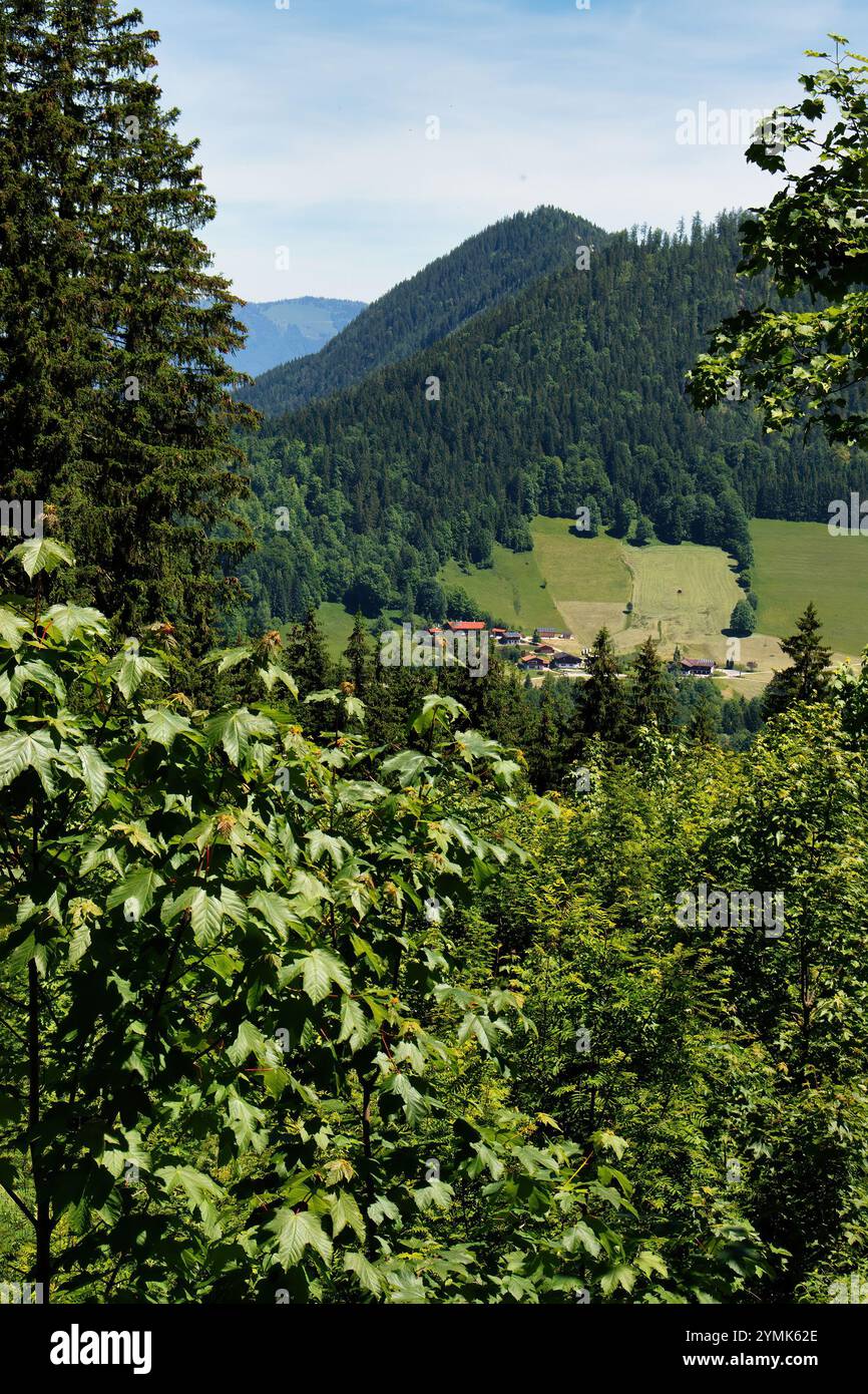 Small village in a valley surrounded by mountians with green trees and ...