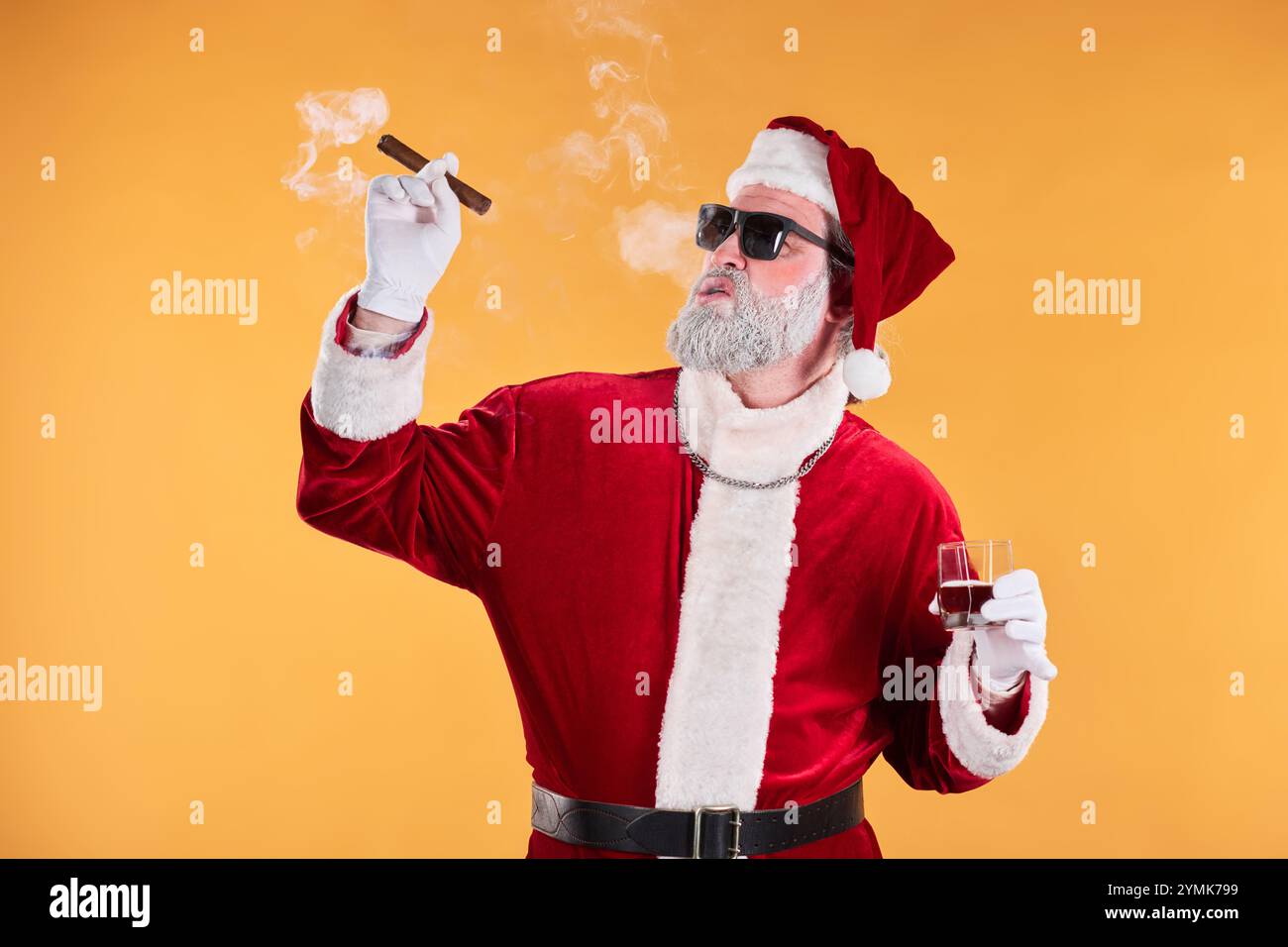 Elderly Santa Claus dressed in traditional costume holding cigar and ...