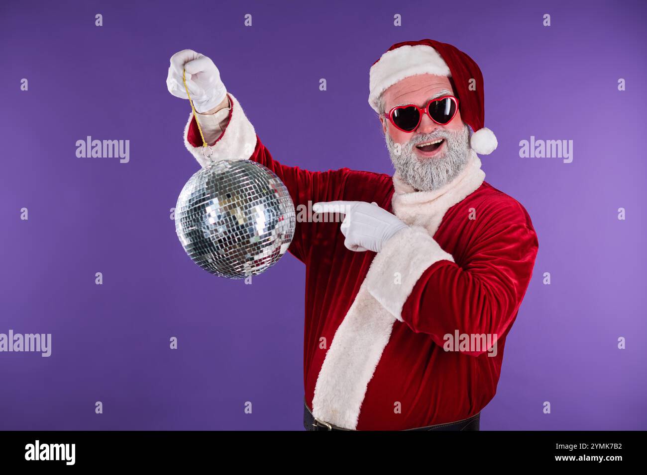 Santa Claus wearing vibrant red suit and white gloves is holding a ...