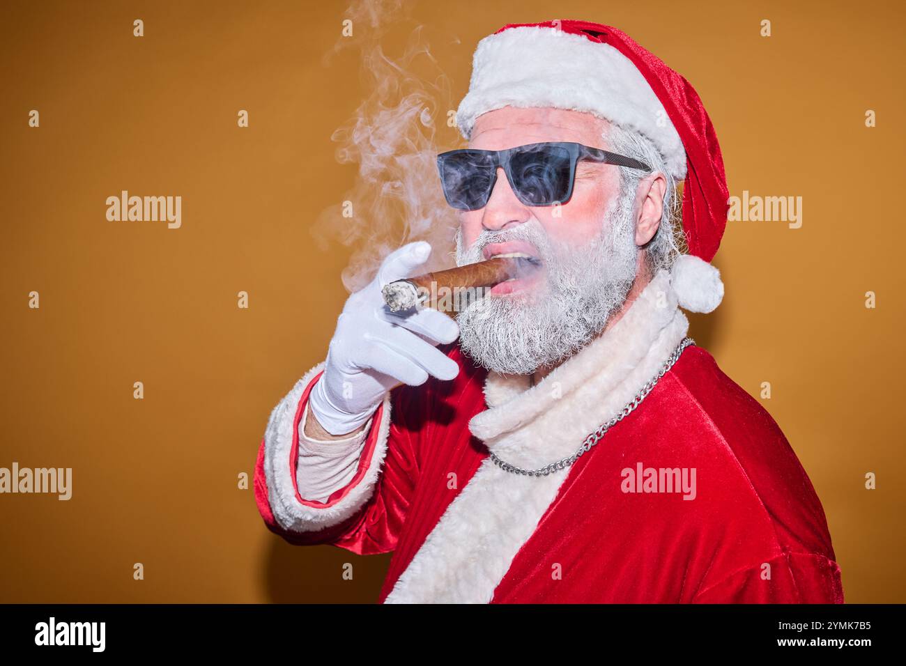Santa Claus wearing sunglasses and smoking cigar while posing against a ...