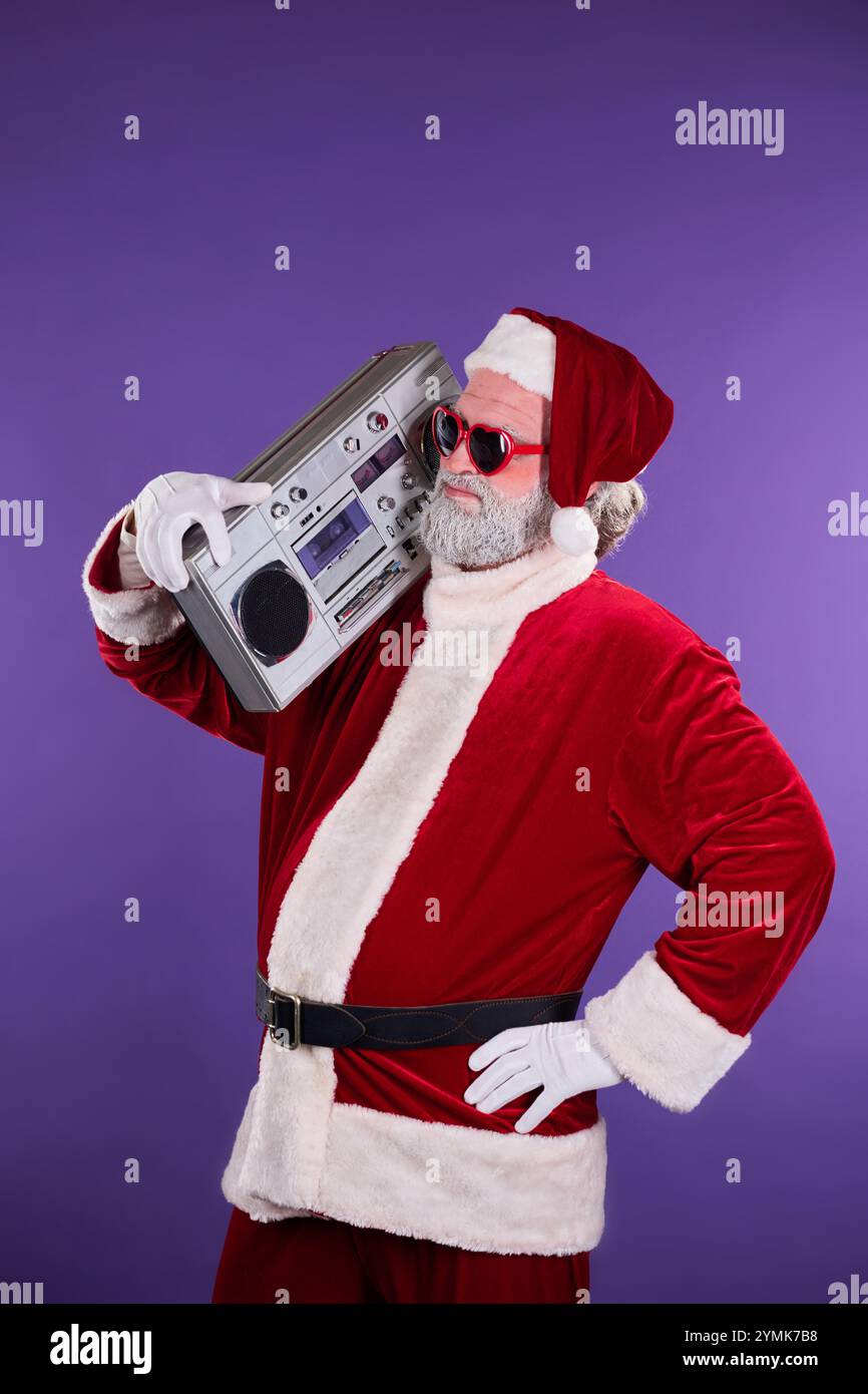 Santa Claus is dressed in traditional red suit and holding boom box on ...