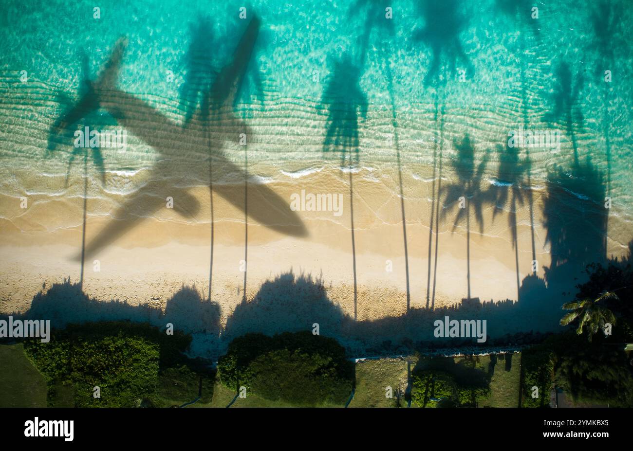 Airplane shadow flying over beautiful exotic tropical beach with sunny cay - Summer vacation ...