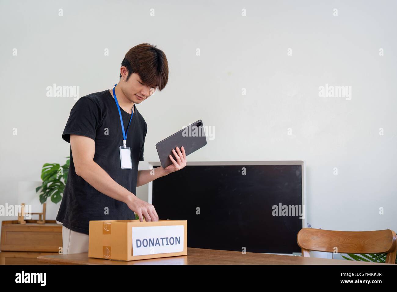 Young Volunteer Finalizing Donation Box Contents for Charity Drive ...