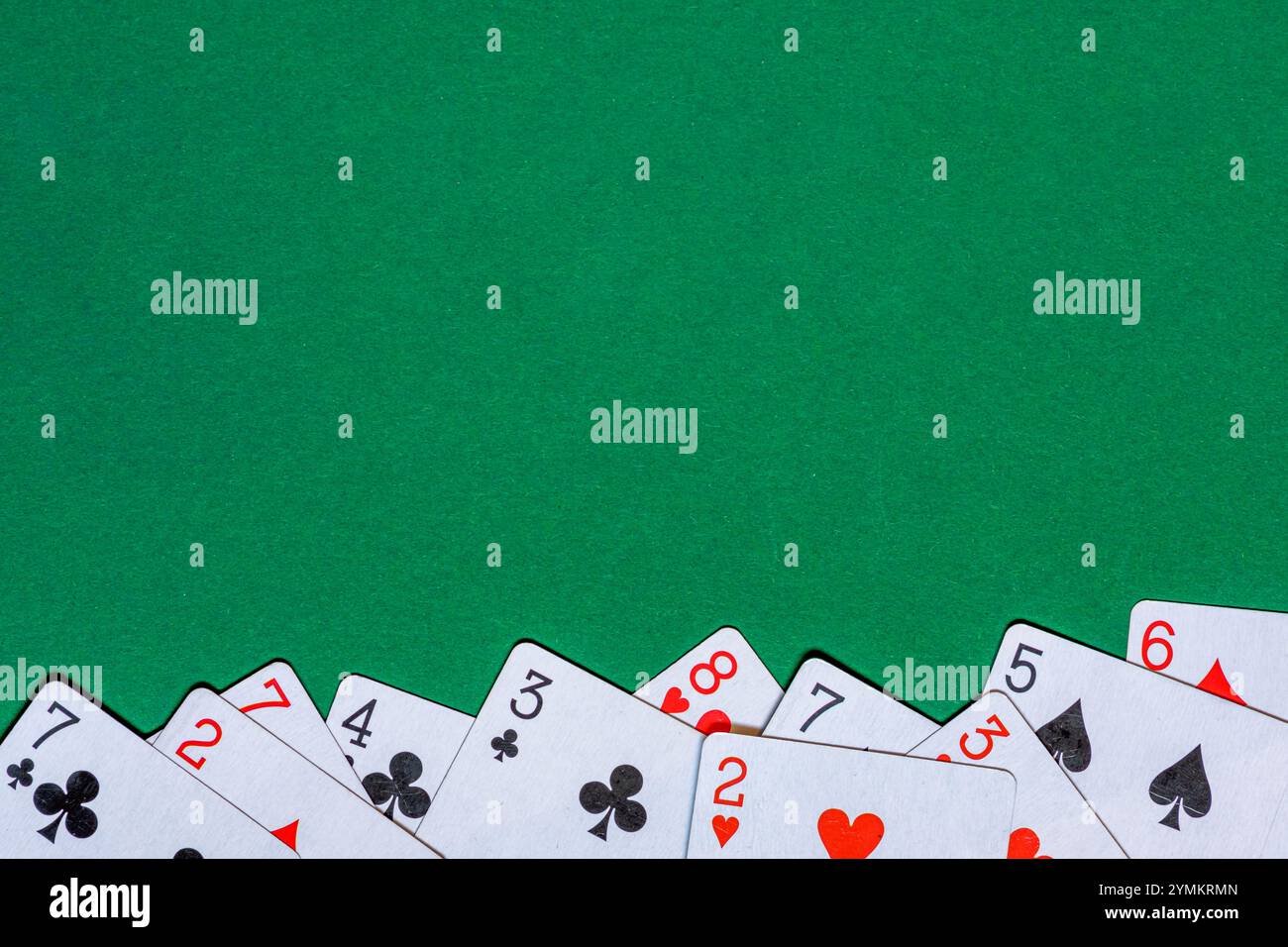 Playing cards on green felt casino table. Background with copy space ...