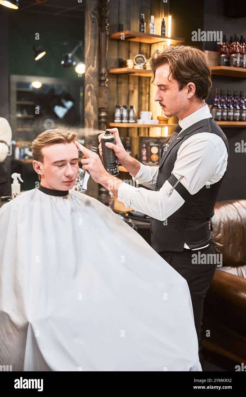 Professional barber using hairspray styling hi-res stock photography ...
