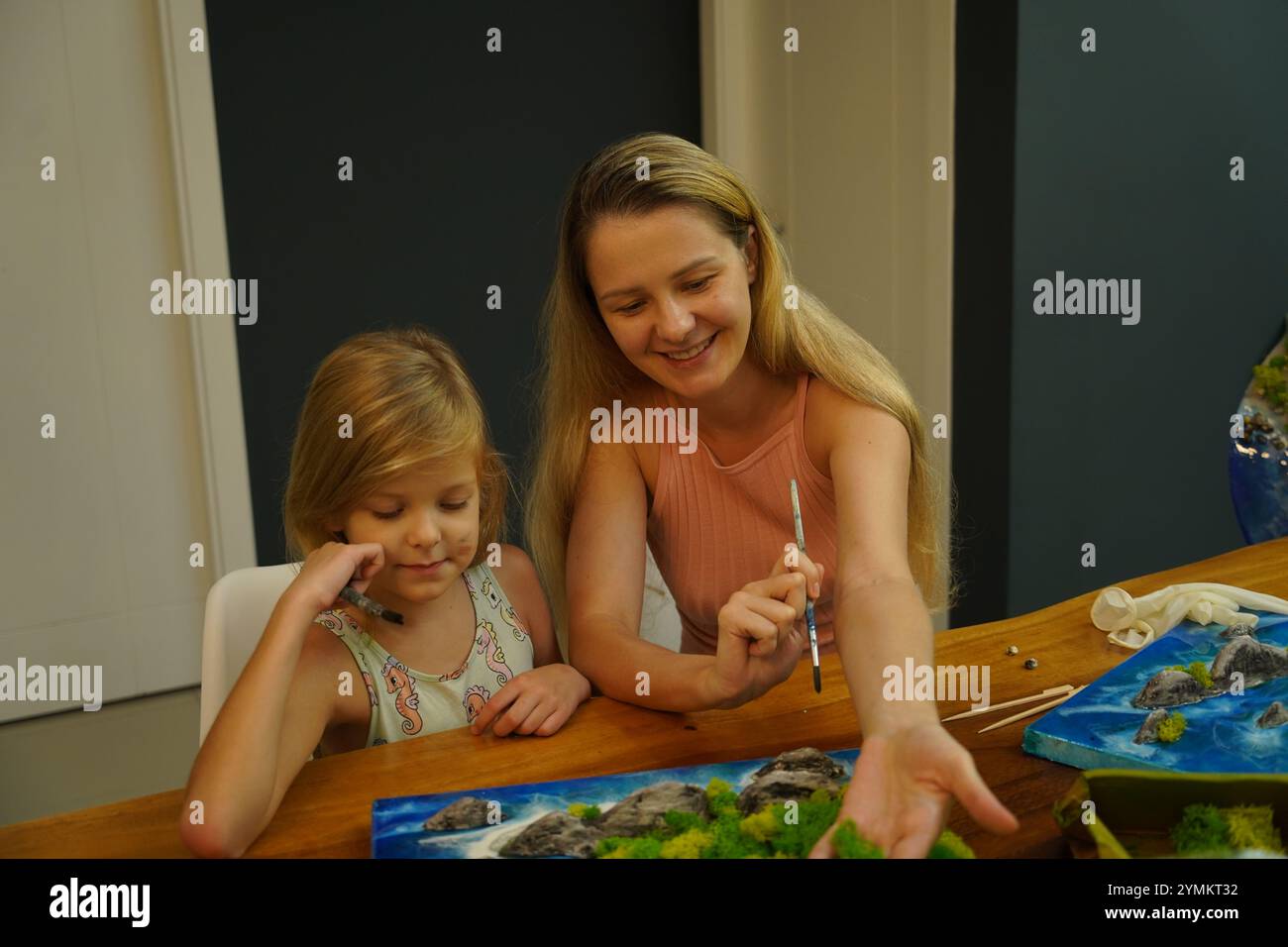 A mother and her daughter craft vibrant natural landscapes Stock Photo ...