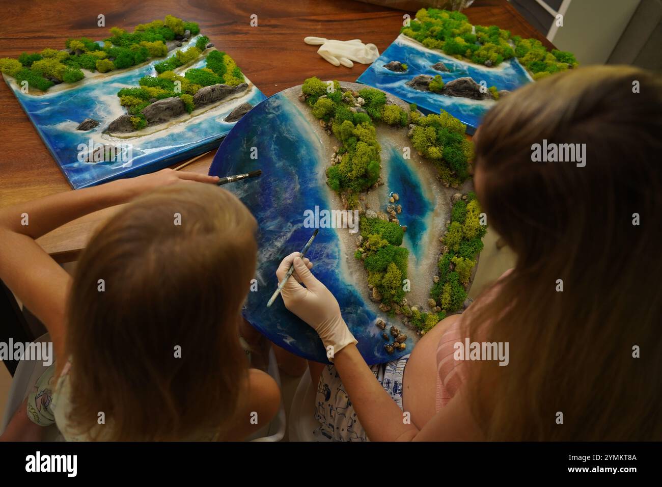 A mother and her daughter craft vibrant natural landscapes Stock Photo ...