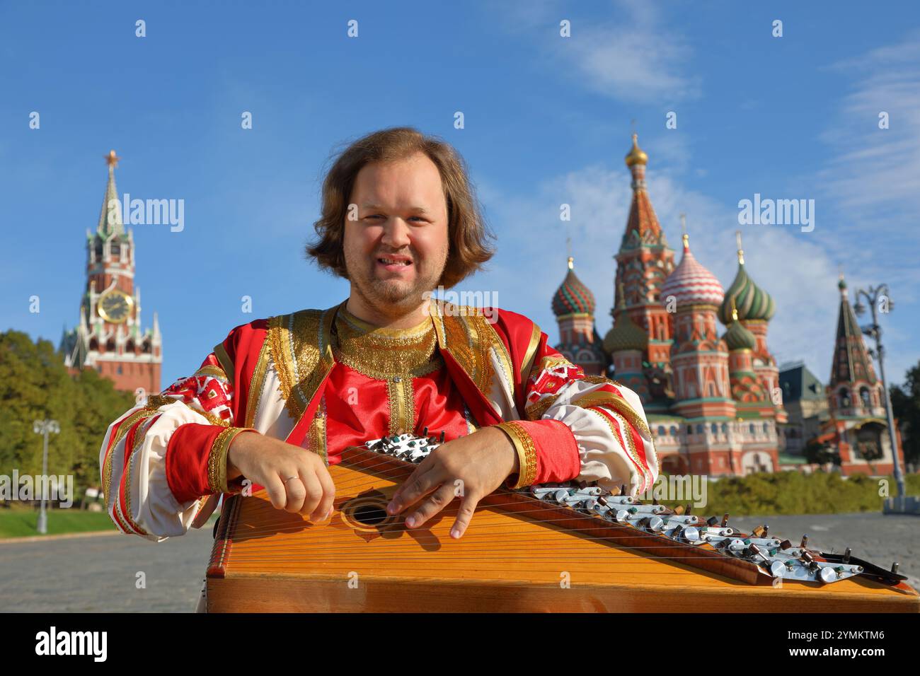 The minstrel in traditional Russian clothes plays an old Russian ...