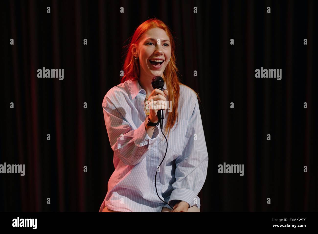 Smiling Woman Performing Stand-Up Comedy on Stage Stock Photo - Alamy
