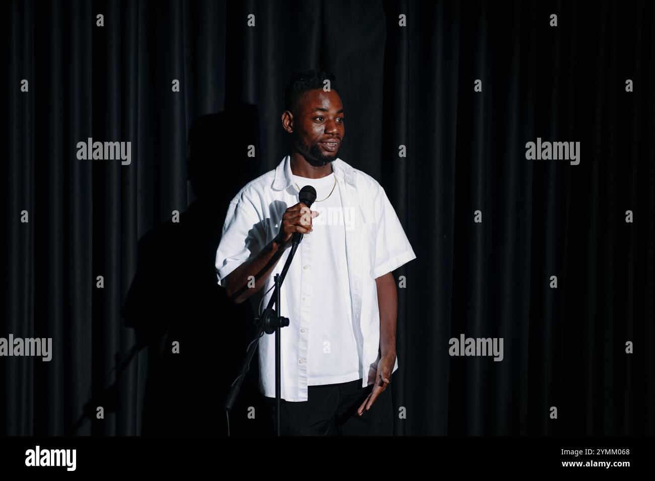 Standing Comedian Holding Microphone on Stage in Spotlight Stock Photo ...