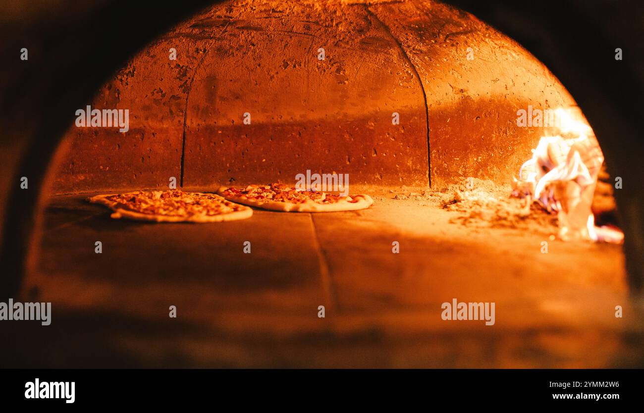 A pizza oven with three pizzas inside. The oven is hot and the pizzas ...