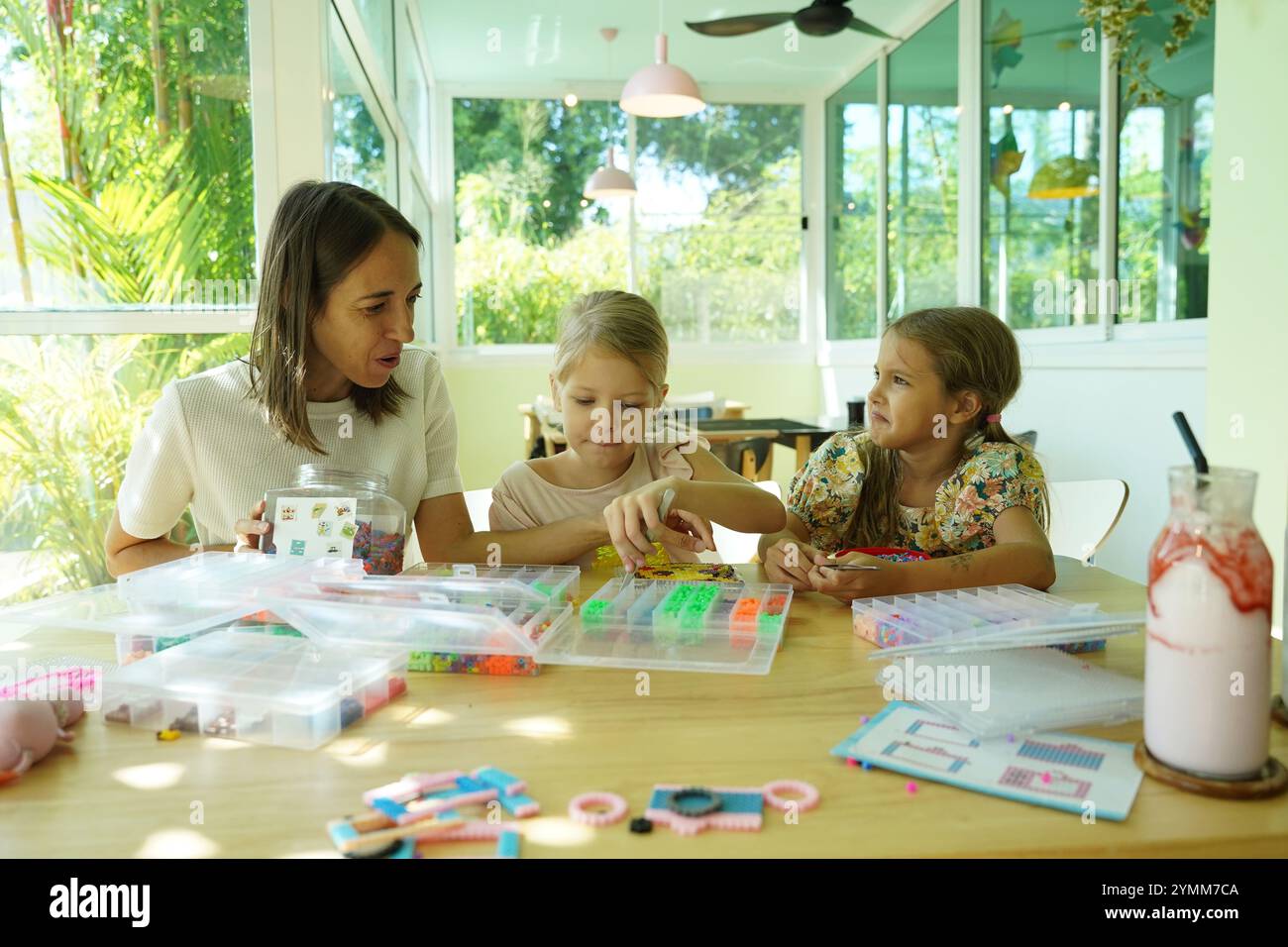 Teacher in workshop teched two girls how to assemble a thermo mosaic ...