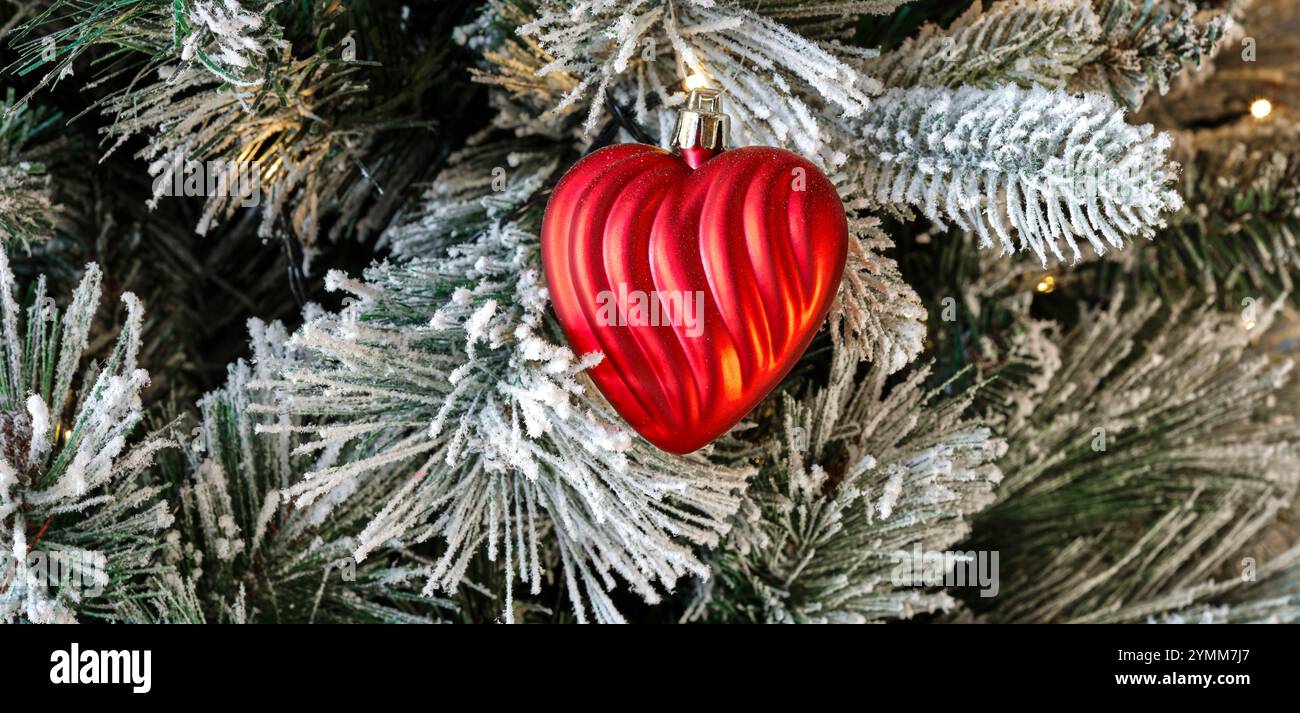 Christmas tree with branches covered with snow and with a red heart ...