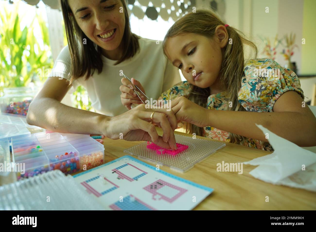 Teacher in workshop teched two girls how to assemble a thermo mosaic ...