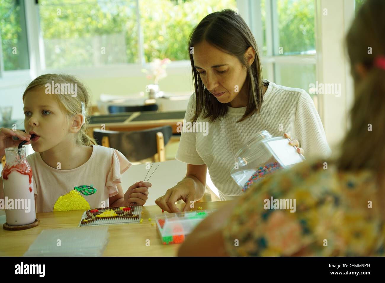 Teacher in workshop teched two girls how to assemble a thermo mosaic ...