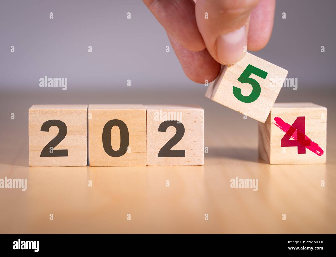 Hand changing the number 4 to 5 to symbolize the change of year from ...