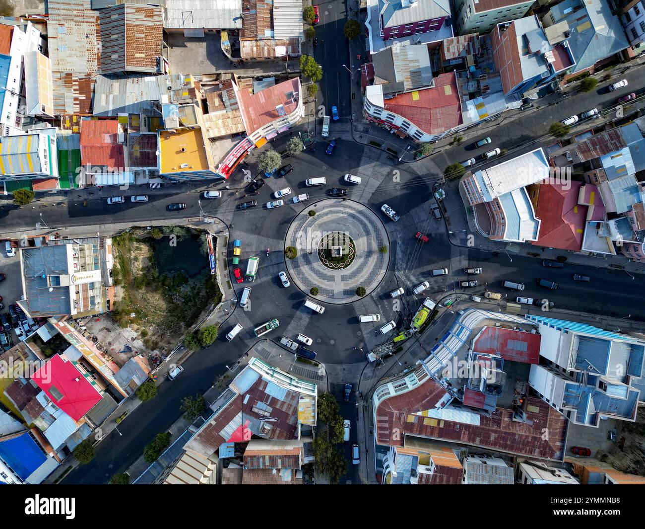 Aerial view of cars driving around a roundabout in a busy city center, showcasing urban ...