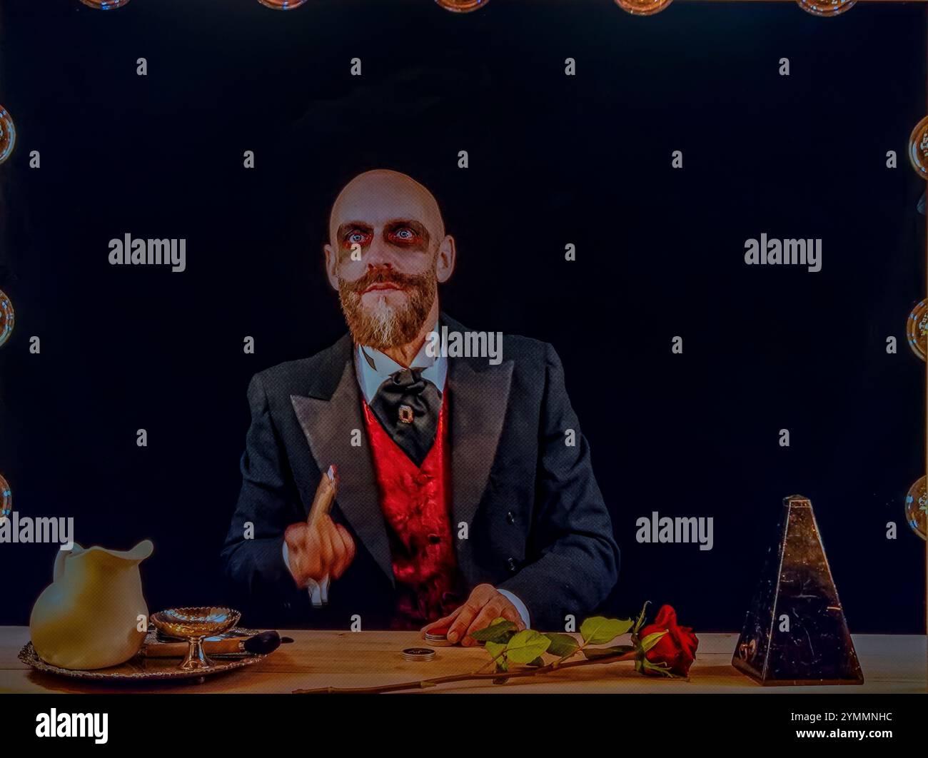 Bald male stage actor applying theatrical makeup in his dressing room ...