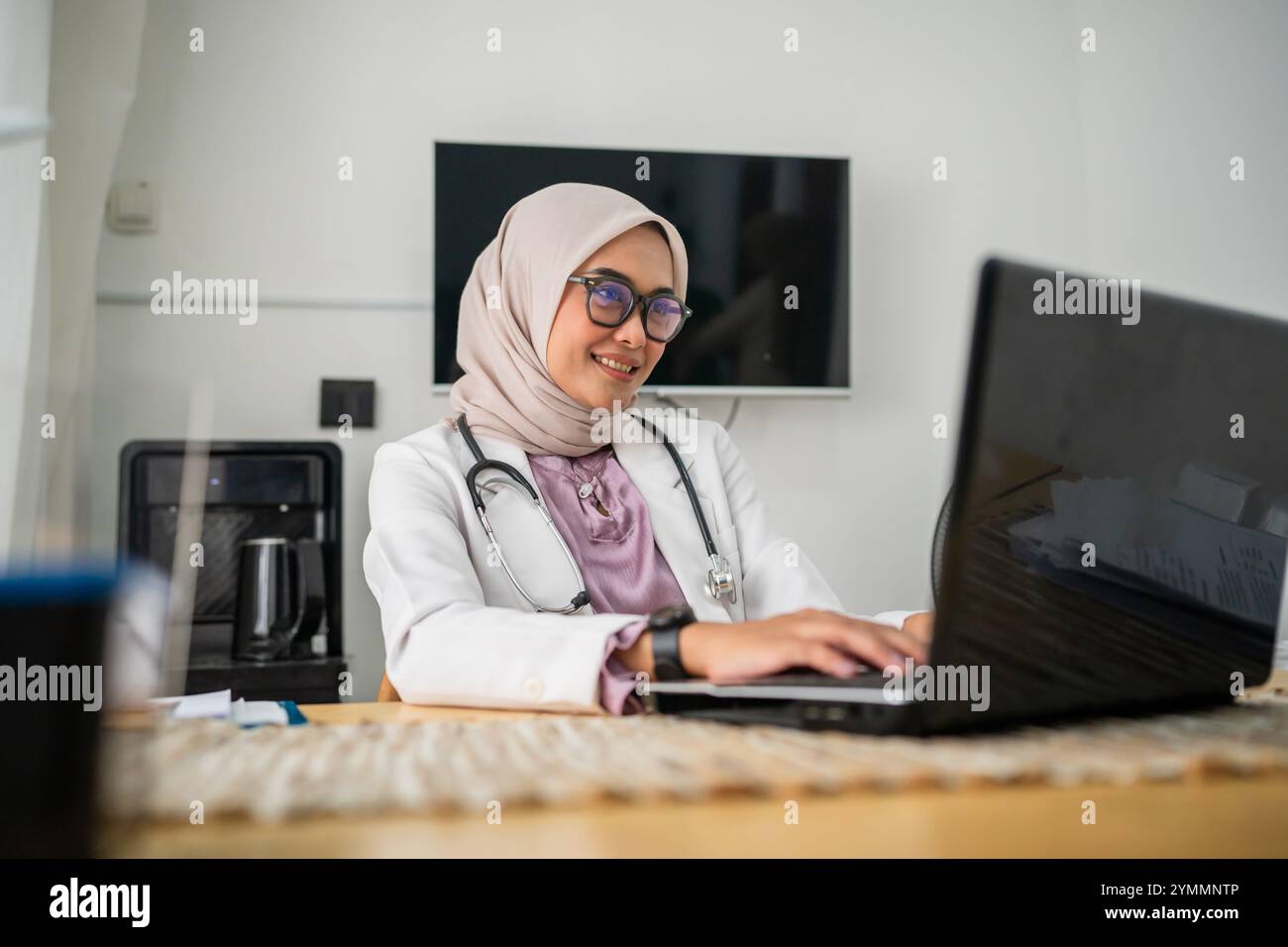 A Female Doctor is Working on a Laptop Inside a Modern Clinic ...