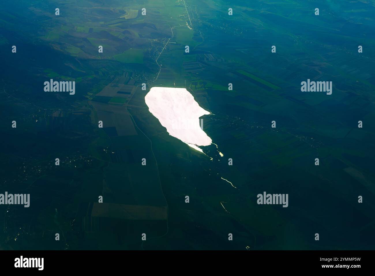 Aerial view of dark landscape with a lake in center. Surrounding area ...