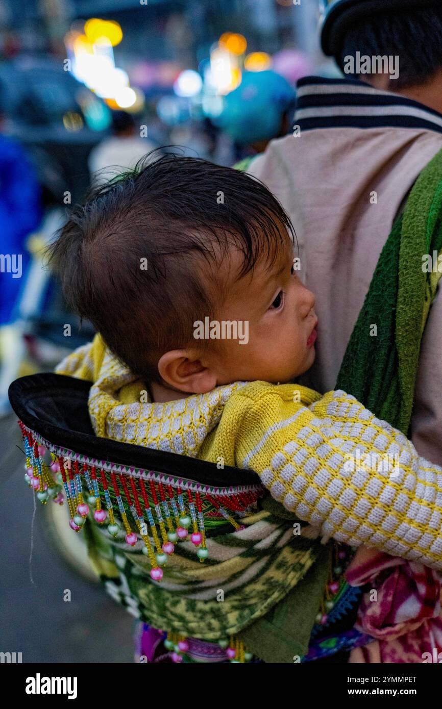 Vietnamese mother carrying her baby on her back in a traditional ...