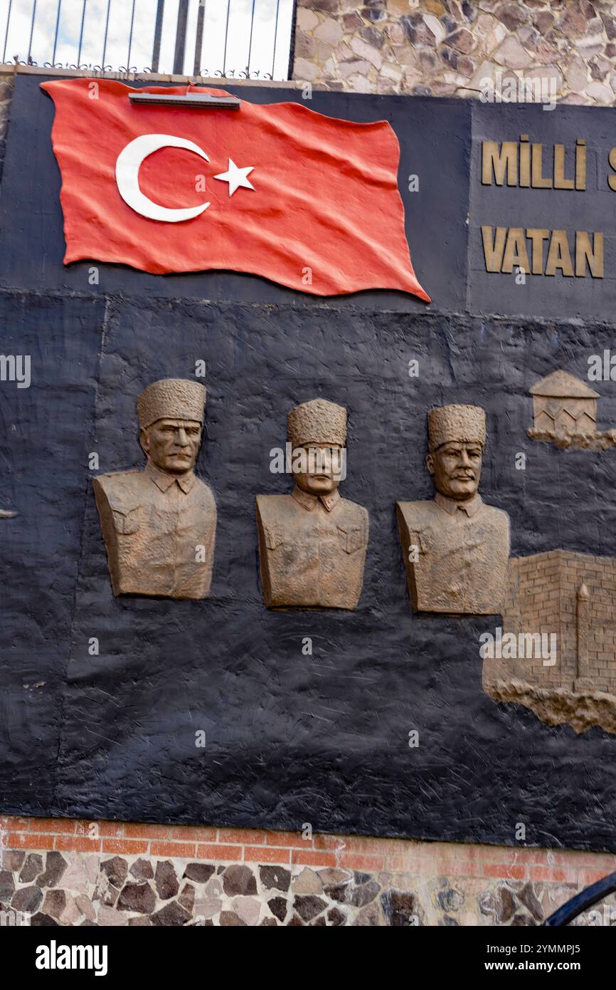 Turkish flag waving proudly above bas relief busts of national heroes ...